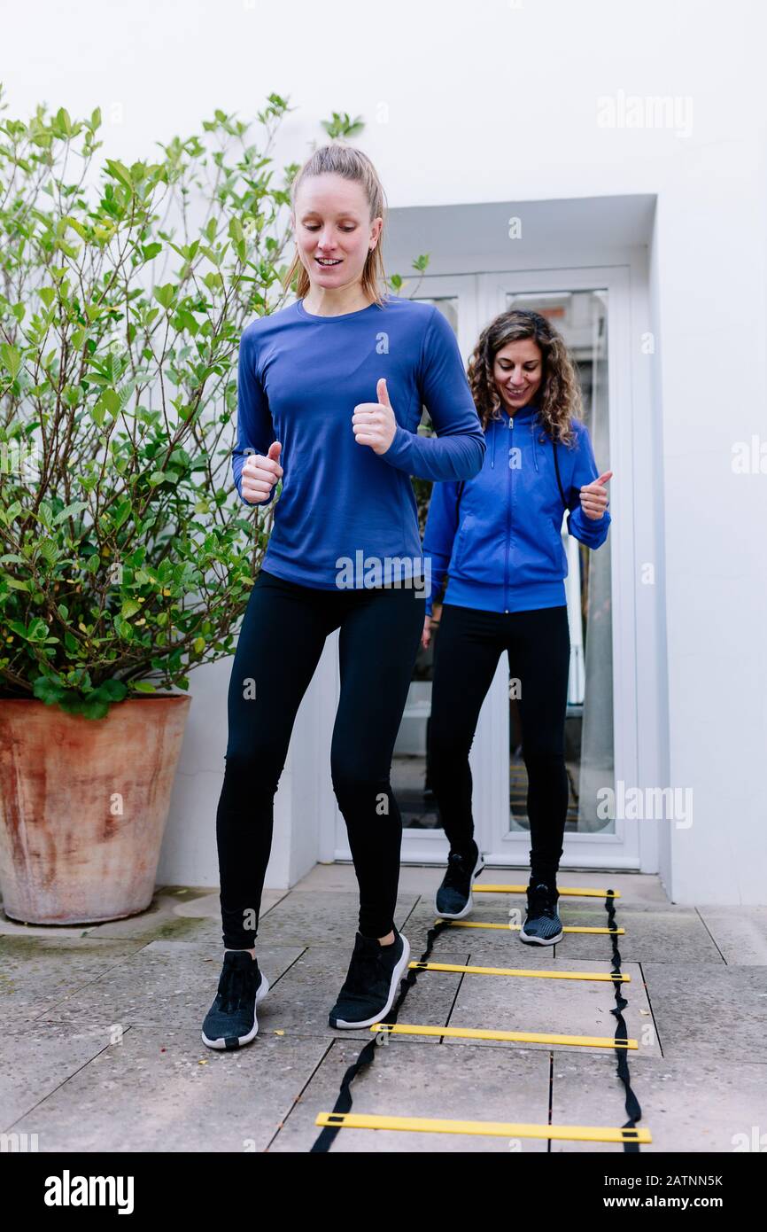 Two young women doing agility ladder exercise on a terrace Stock Photo ...