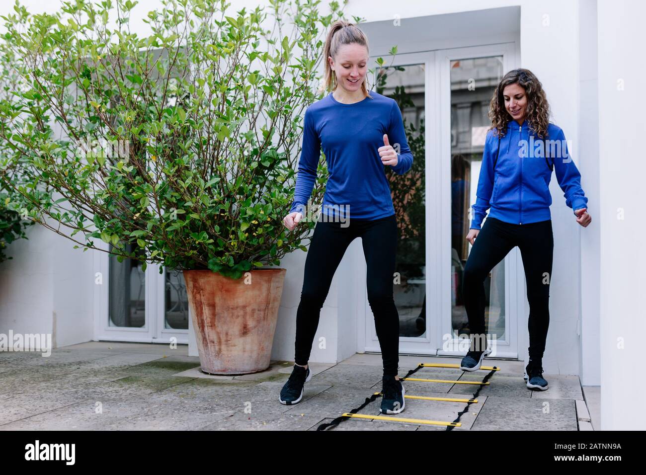 Two young women doing agility ladder exercise on a terrace Stock Photo ...