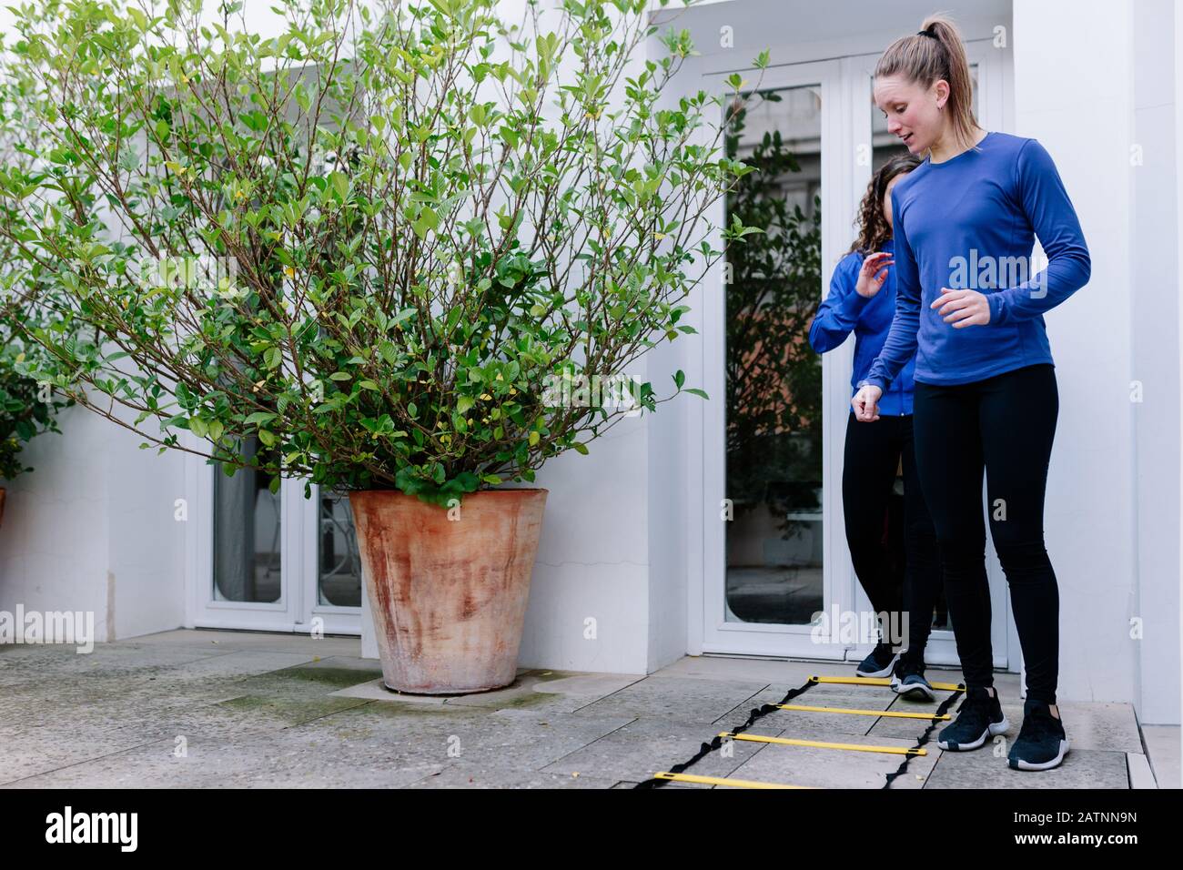 Two young women doing agility ladder exercise on a terrace Stock Photo ...