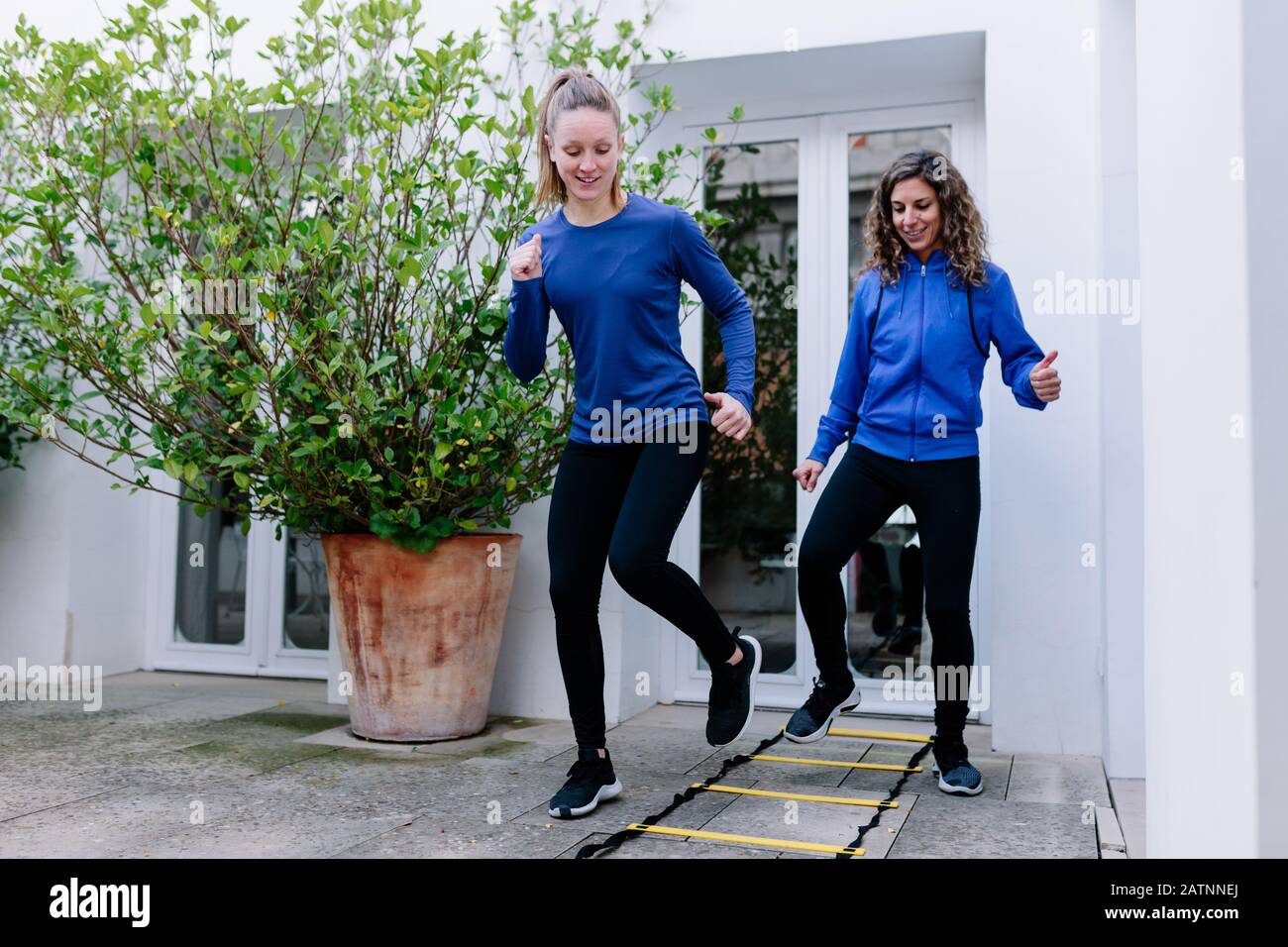 Two young women doing agility ladder exercise on a terrace Stock Photo ...