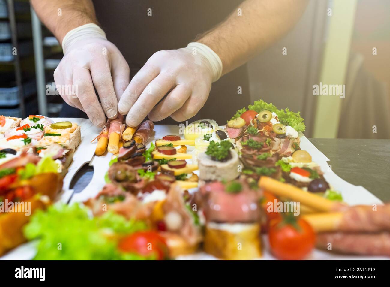 Close up of chef arranging buffet meal canape finger food on paper ...