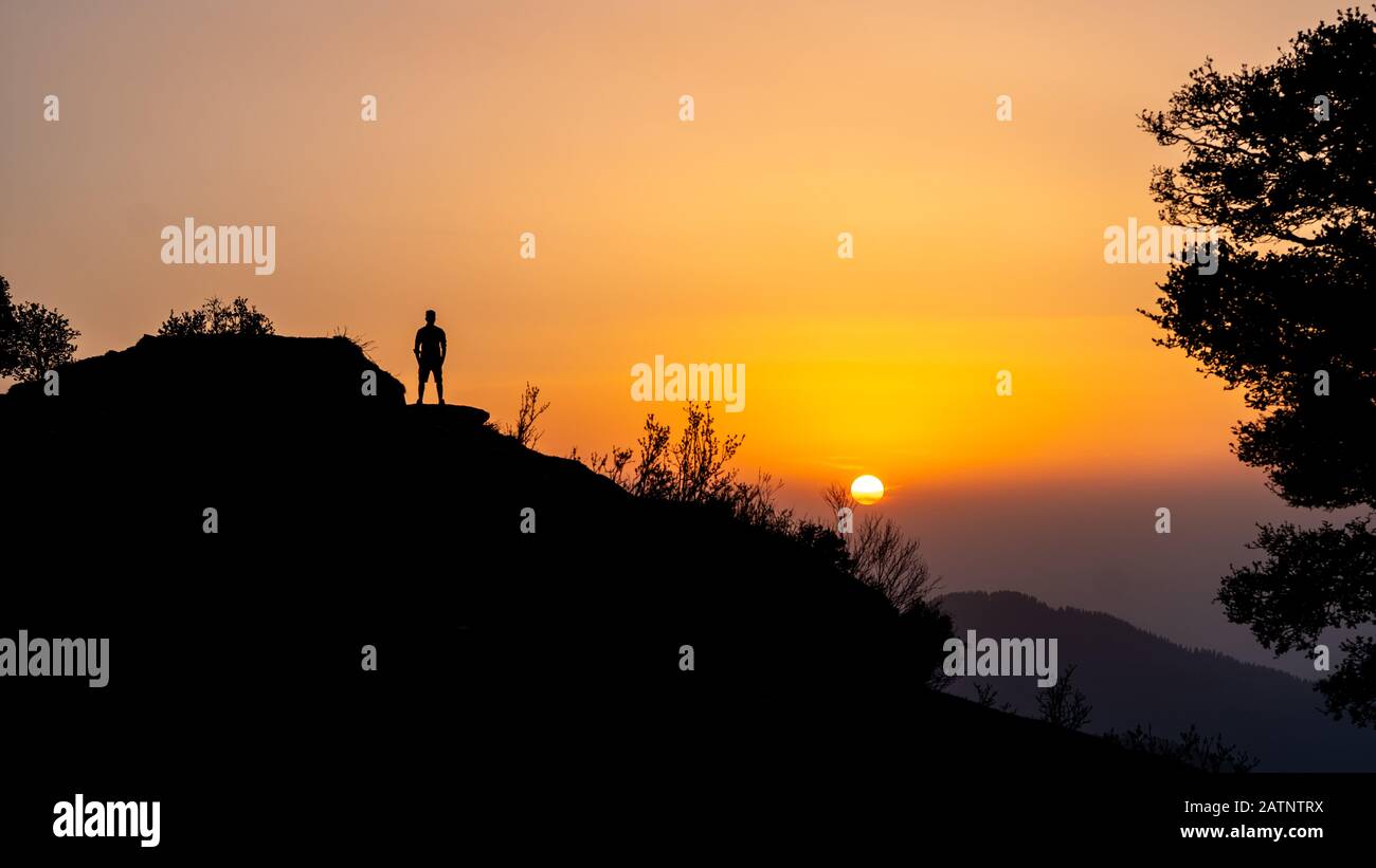 Person overlooking mountain sunset silhouette Stock Photo - Alamy