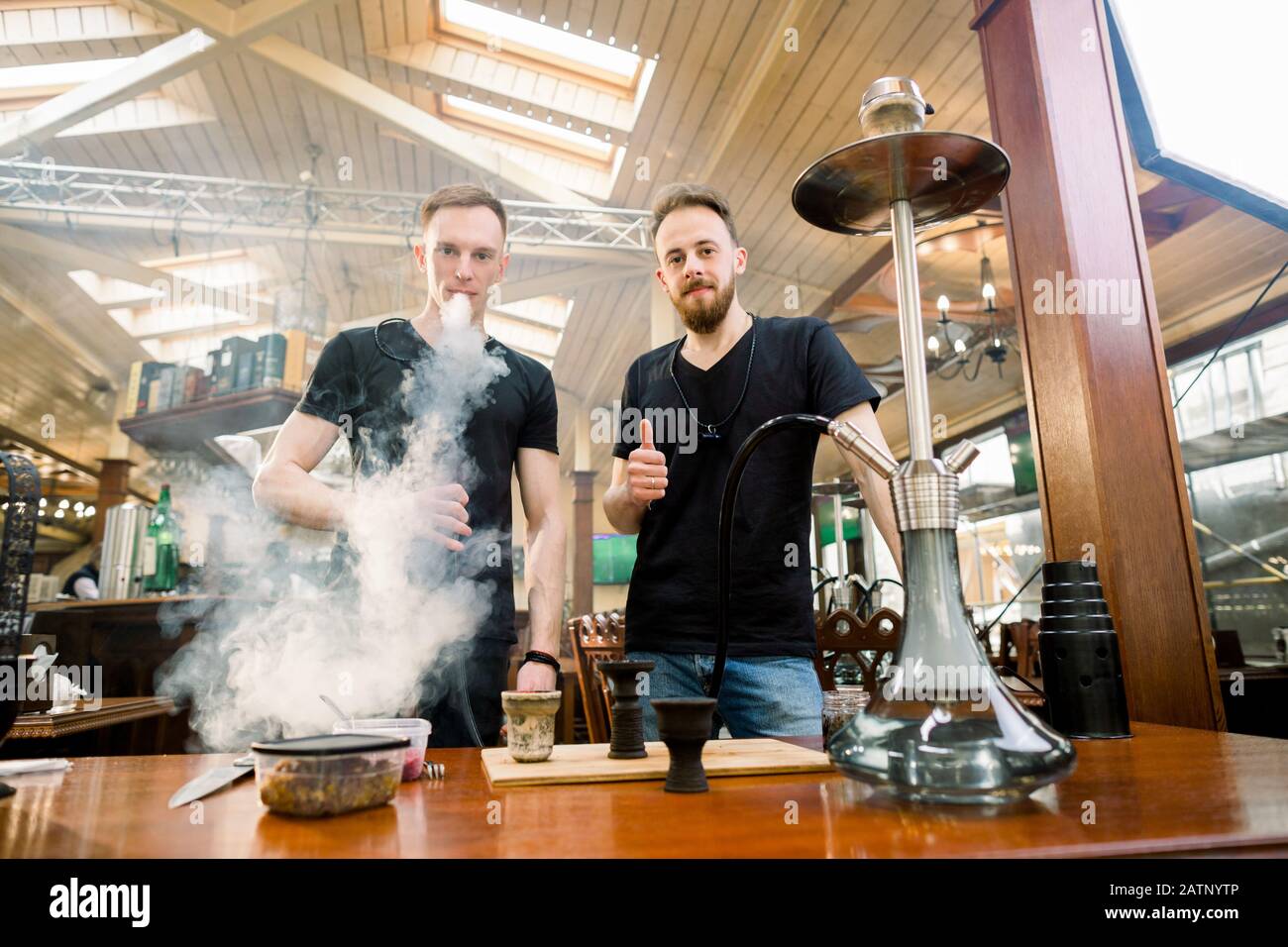 Hookah in the process preparations. Two young boys prepare hookah sisha ...
