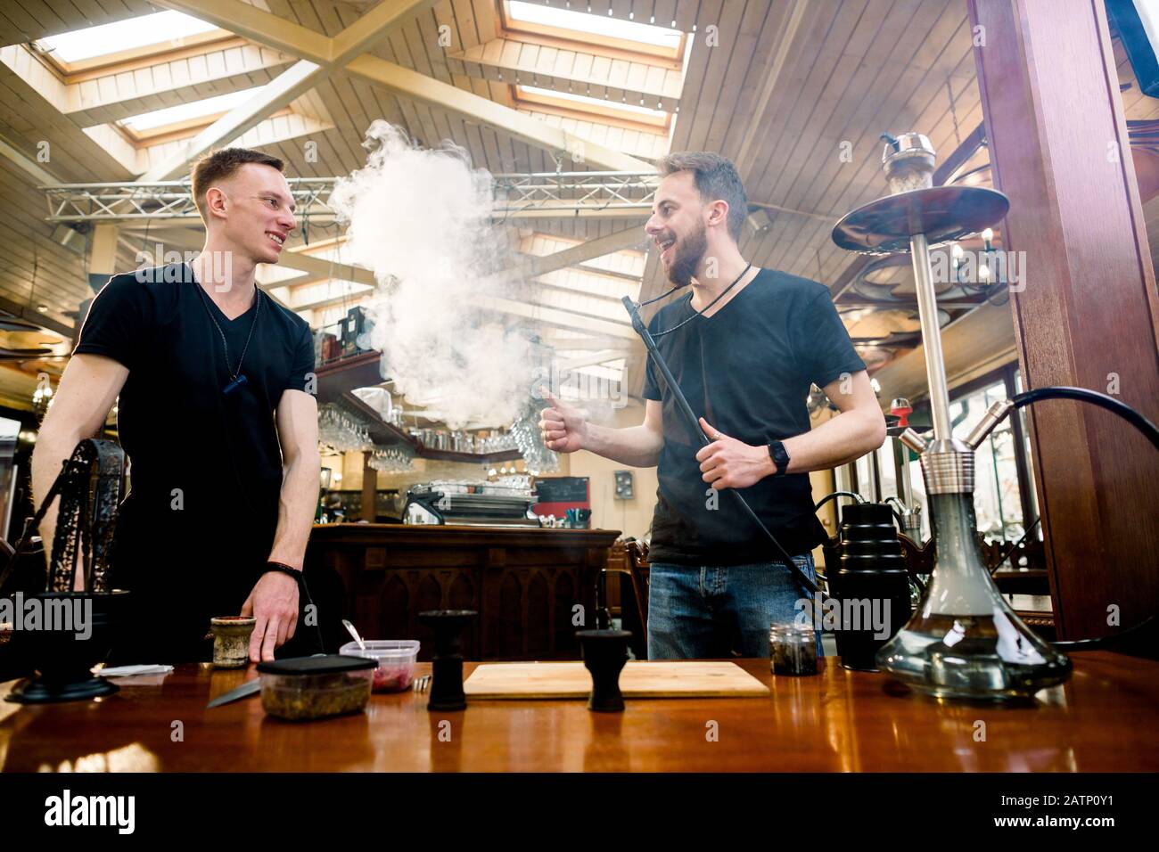 Two masters barmen prepare hookah sisha in hookah bar. Tabaco ...