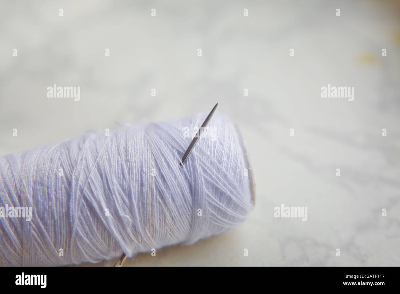 White bobbin with needle isolated on white .Close up sewing thread with ...