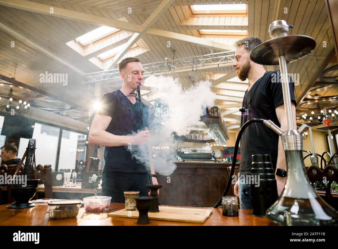 Two masters barmen prepare hookah sisha in hookah bar. Tabaco ...