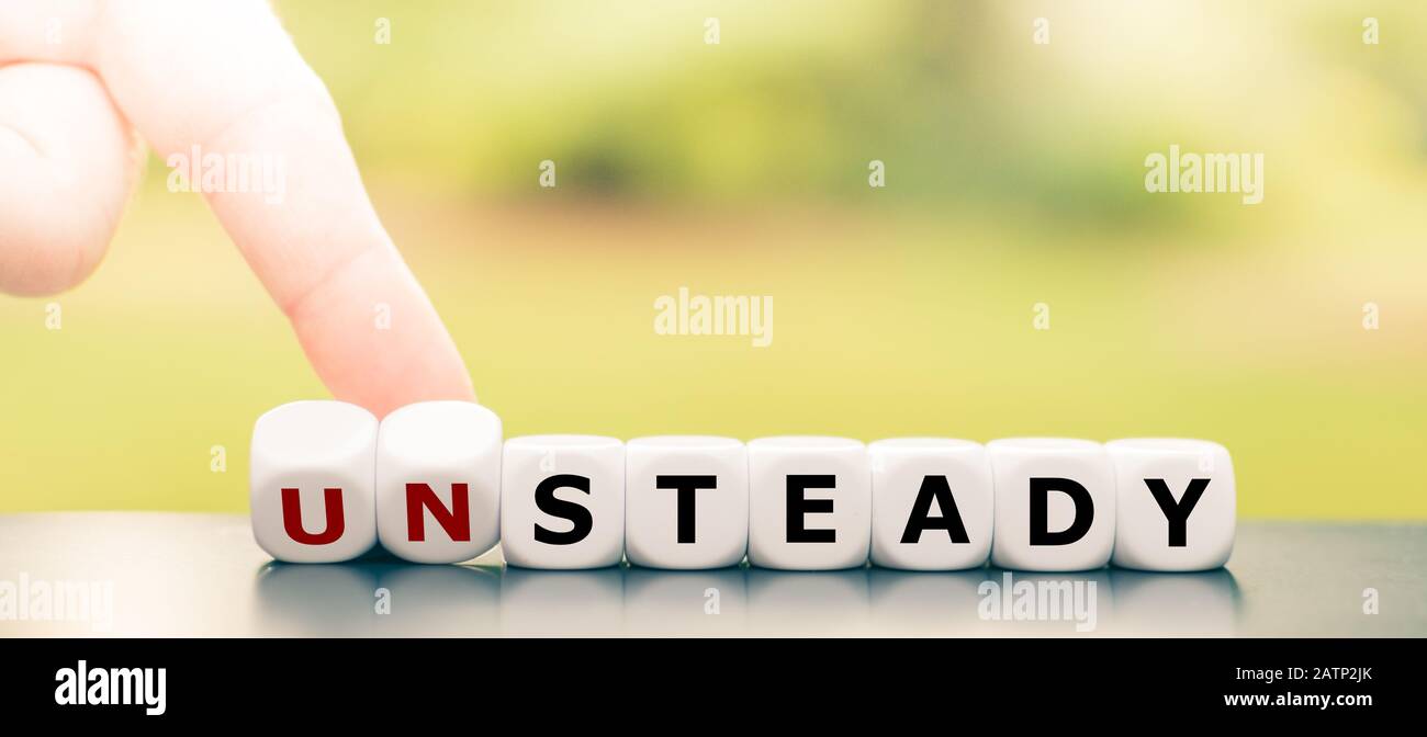 Hand turns dice and changes the word "unsteady" to "steady Stock Photo ...