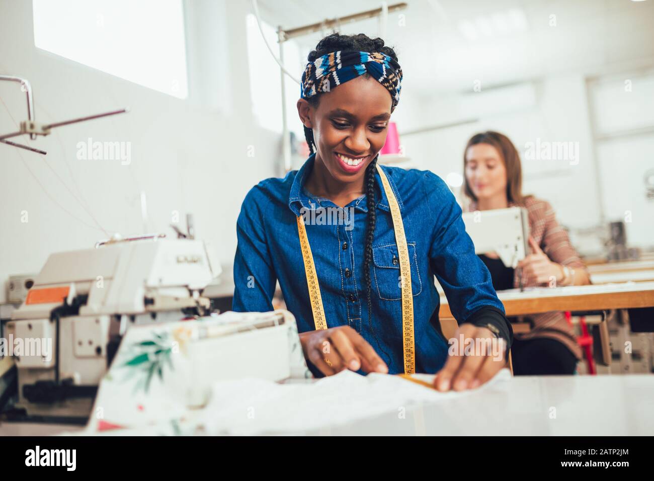 Young african textile worker sewing on production line. Dressmaker ...