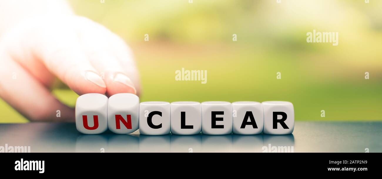 Hand turns dice and changes the word "unclear" to "clear Stock Photo ...