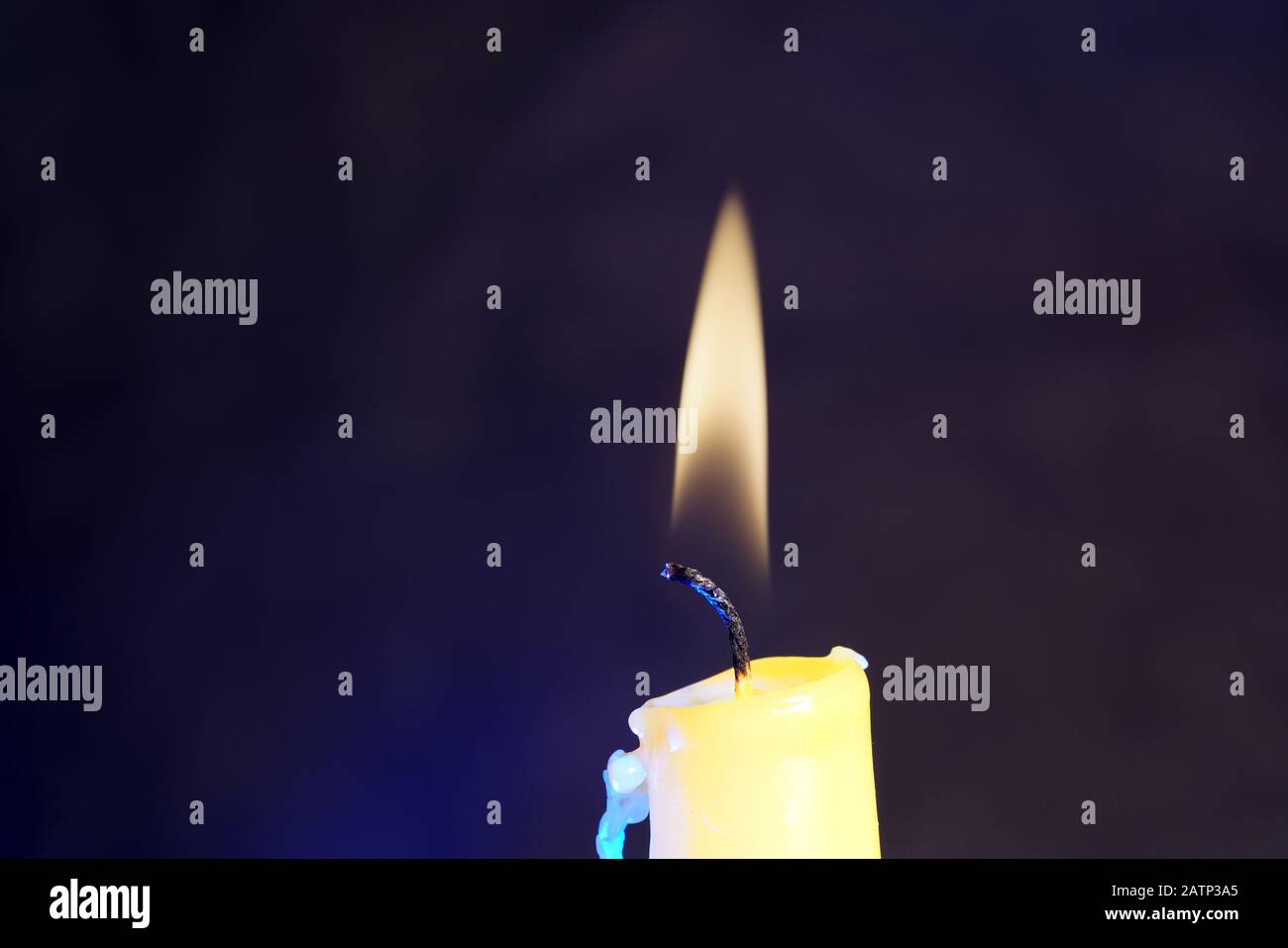 Yellow candle with smoke and flame photographed in the studio with ...