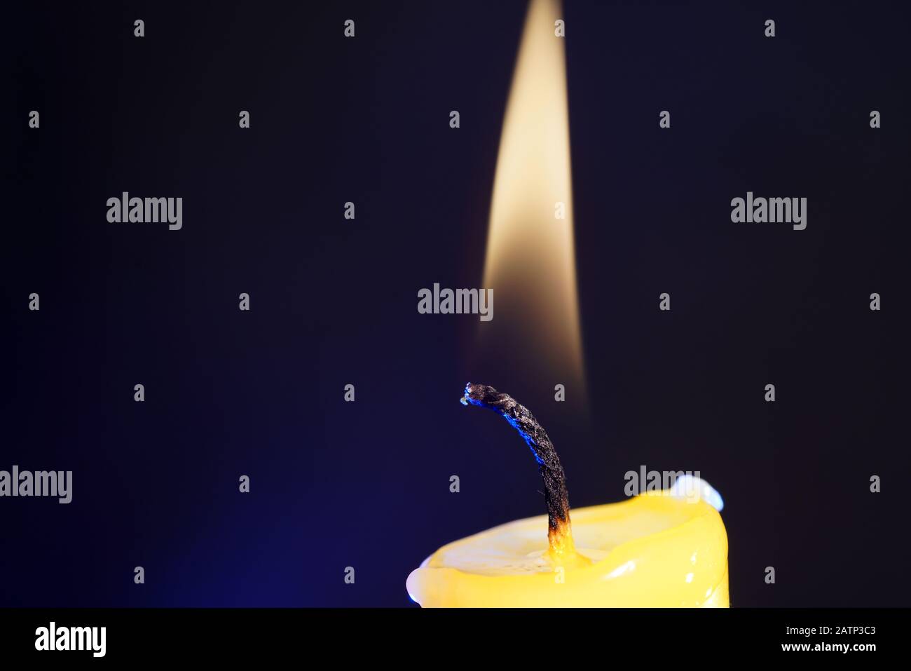 Yellow candle with smoke and flame photographed in the studio with ...