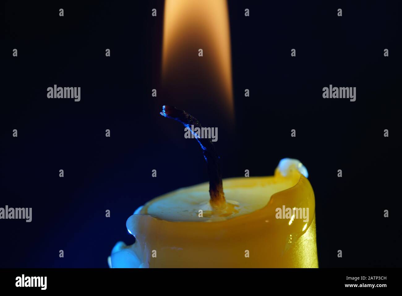Yellow candle with smoke and flame photographed in the studio with ...