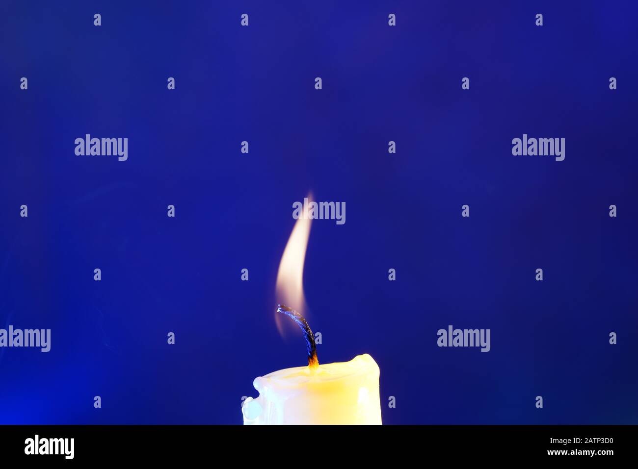 Yellow candle with smoke and flame photographed in the studio with ...
