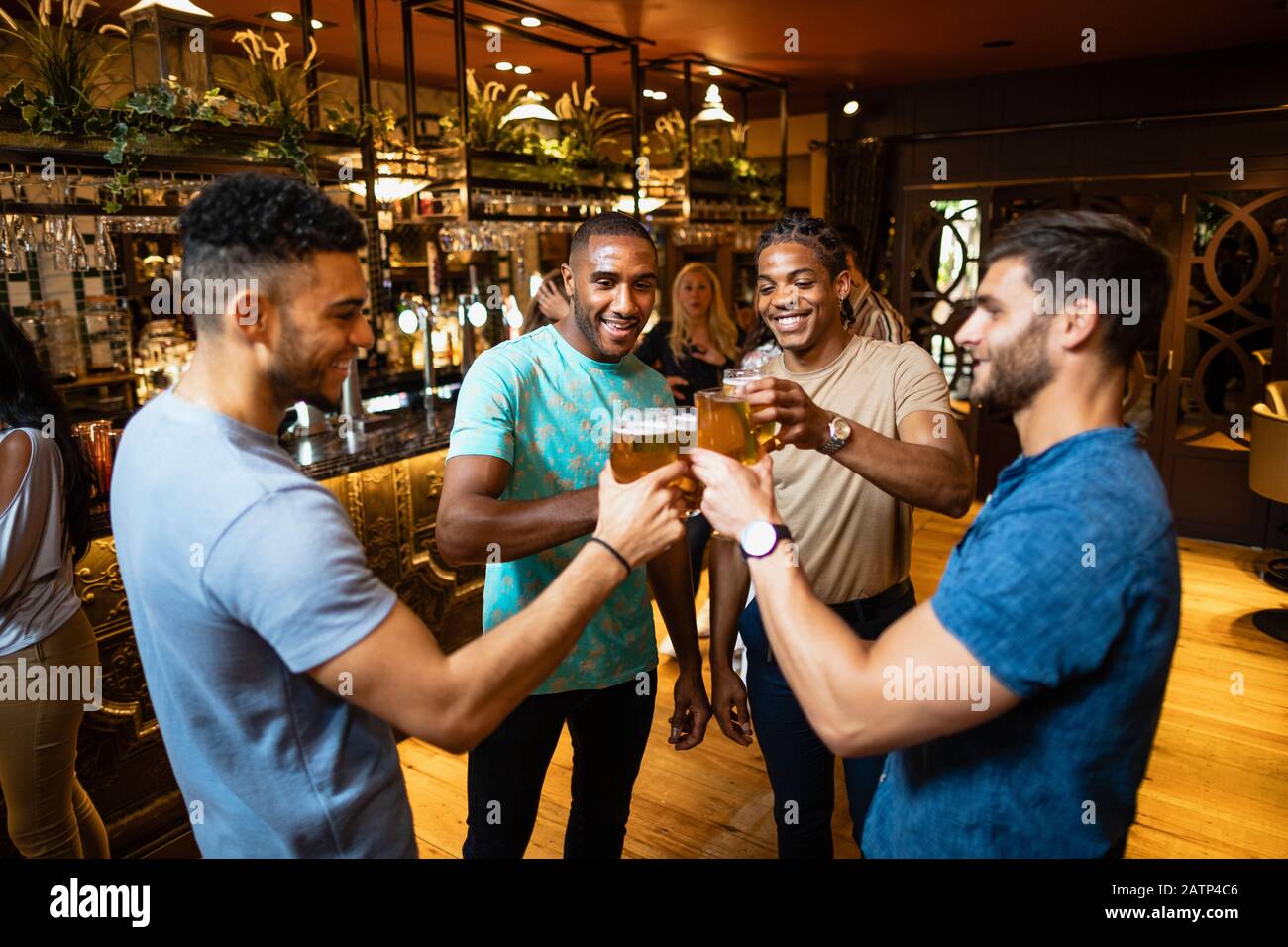A group of male friends having a celebratory toast together in a bar ...