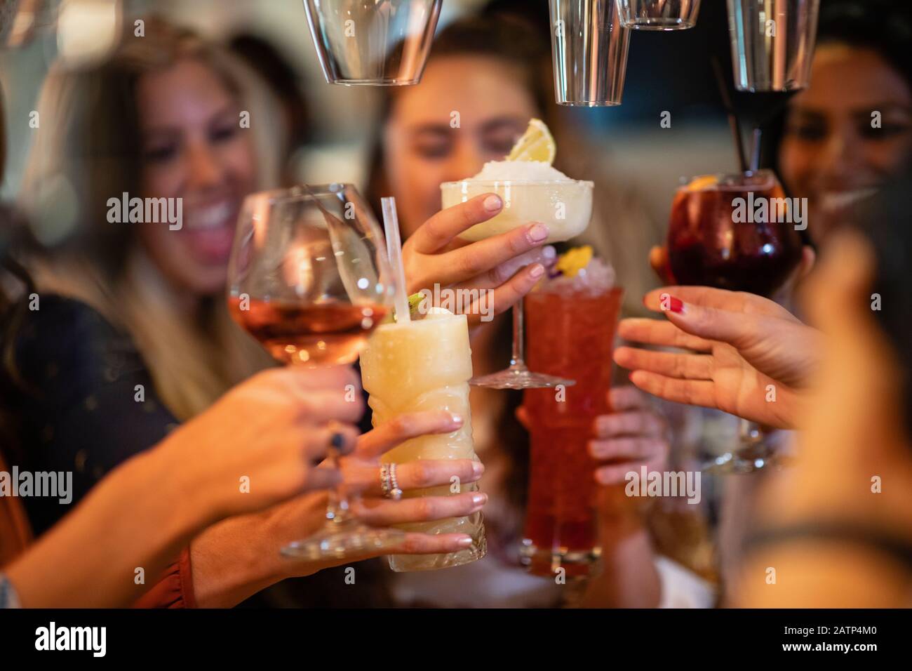 Female friends having drinks and having a celebratory toast together in ...