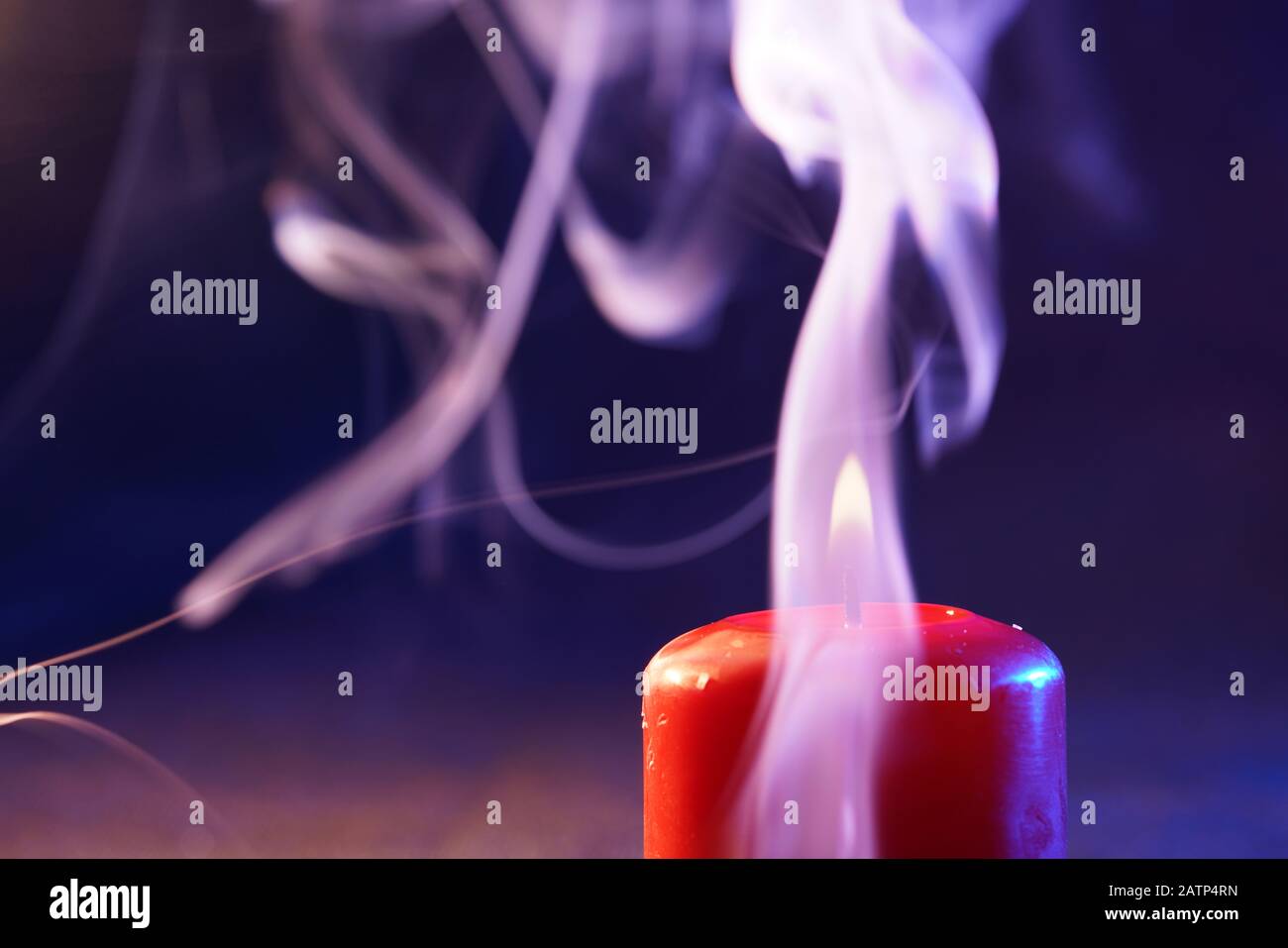 Red candle with smoke and flame photographed in the studio with color ...
