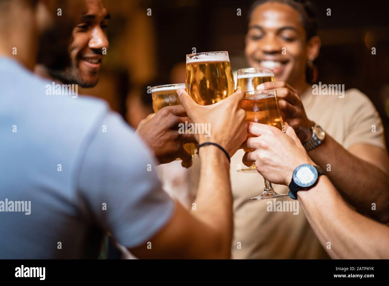 A group of male friends having a celebratory toast togetherat a bar ...