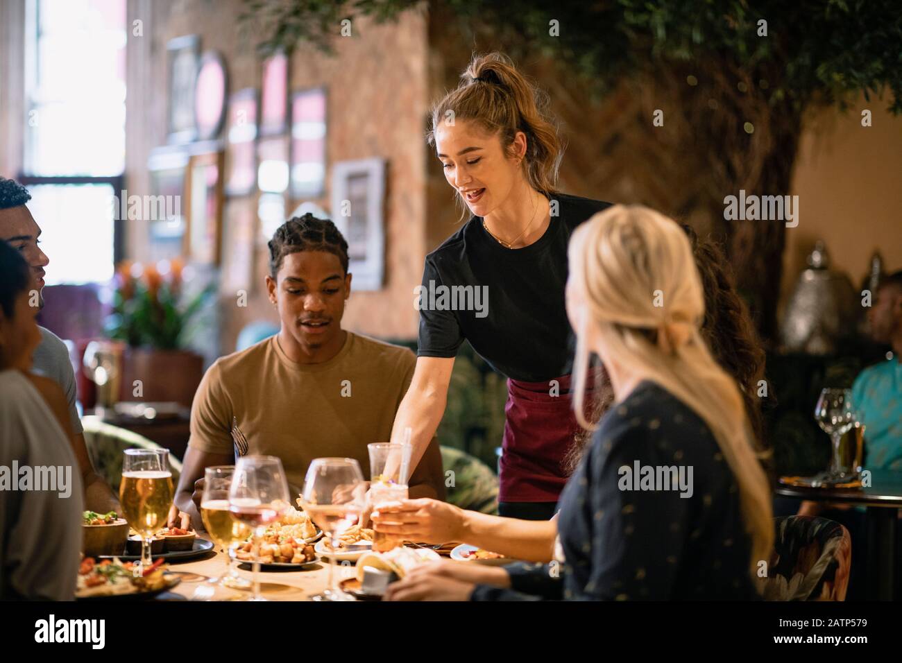 A waitress serving a meal to customers at a restaurant in Newcastle ...