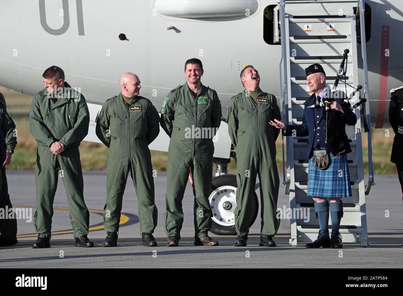 Squadron Leader Mark Faulds (second right) laughs with a piper after ...