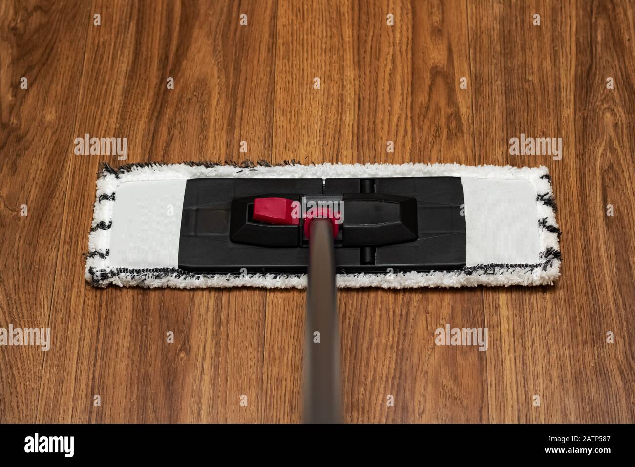 White mop washes wooden floor close up Stock Photo - Alamy