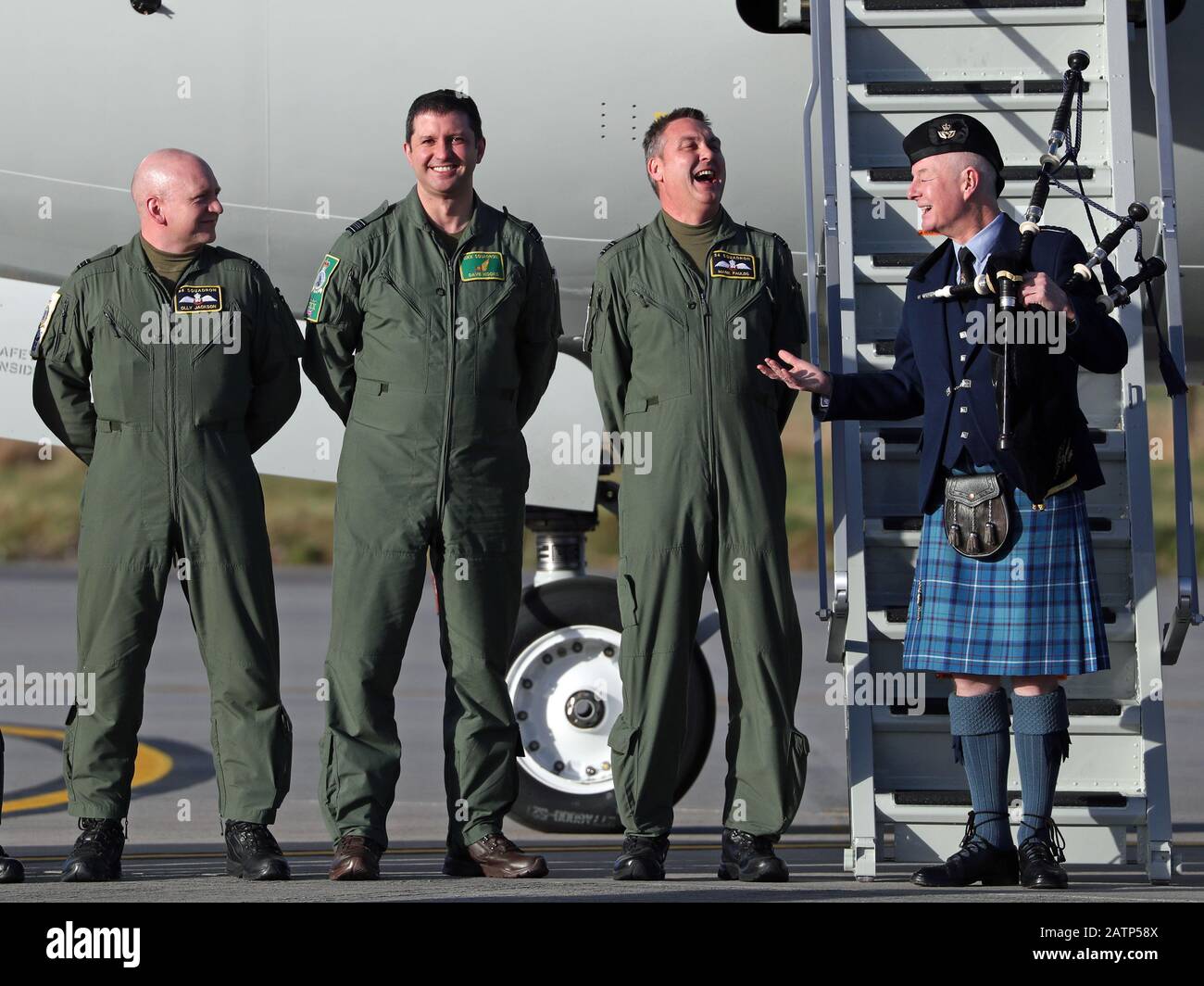 Squadron Leader Mark Faulds (second right) laughs with a piper after ...
