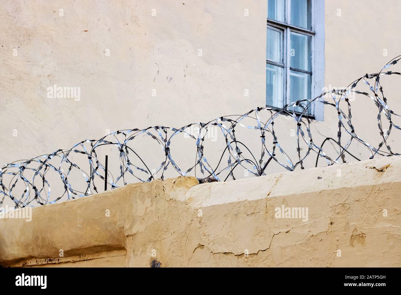 Barbed net on concrete fence of prison Stock Photo - Alamy