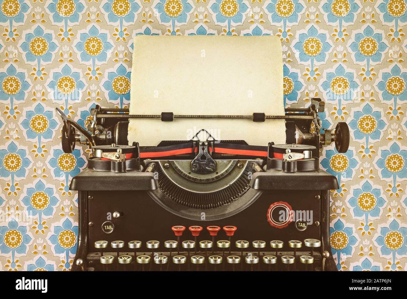 Retro styled image of an old typewriter with a blank sheet of paper in ...