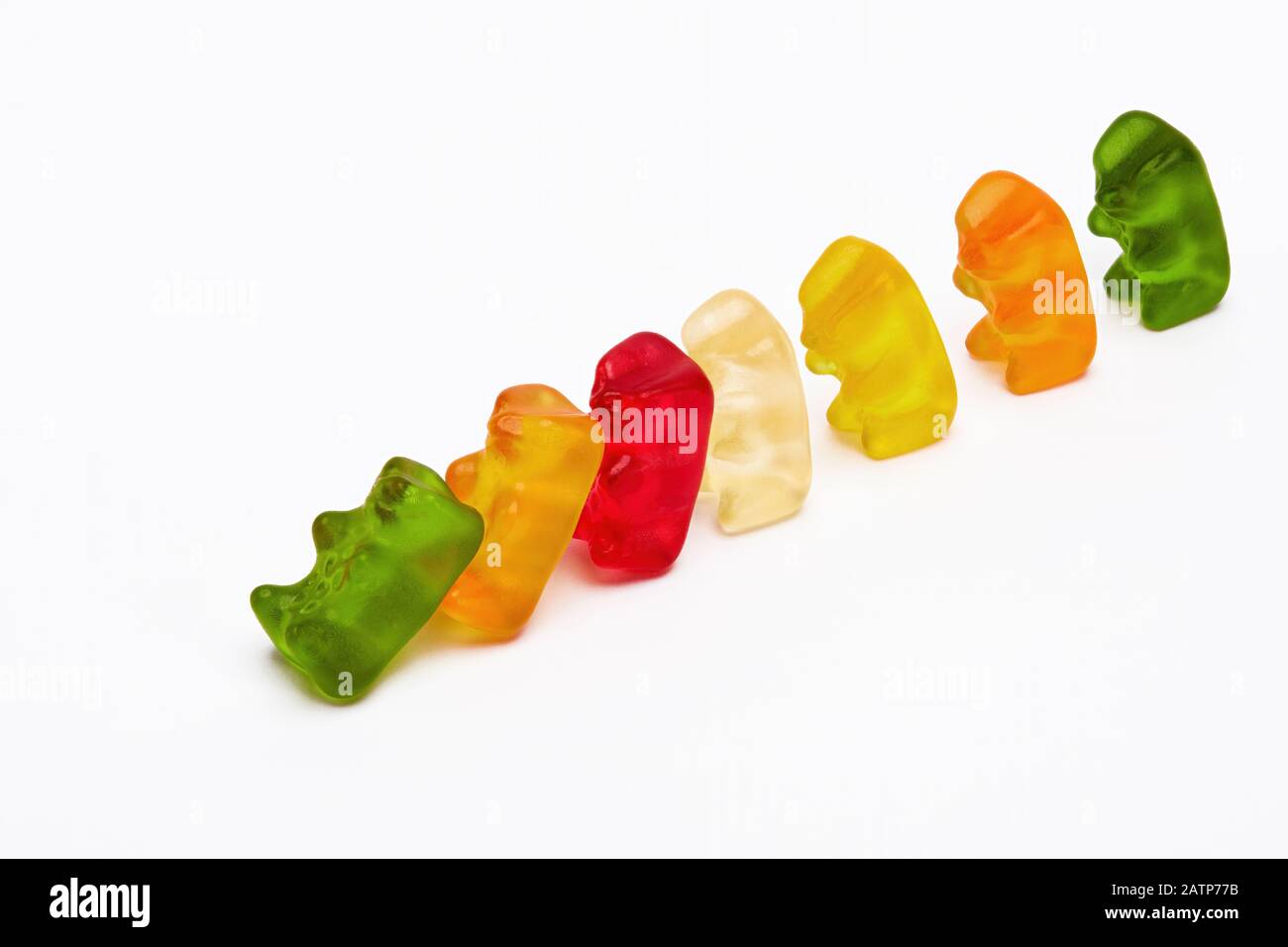 Domino effect concept with colorful gummy bears in line on white ...