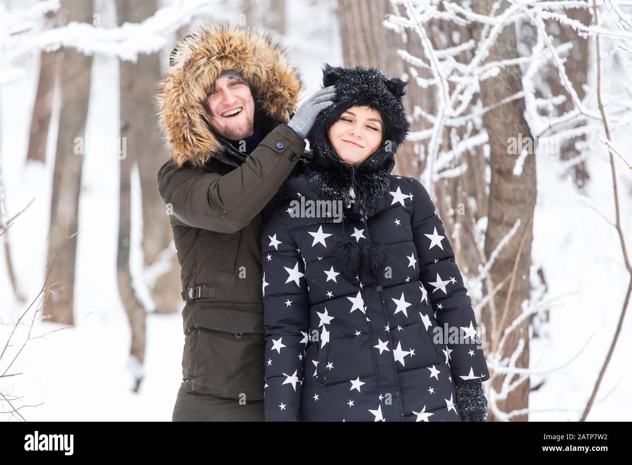 Fun, season and leisure concept - love couple plays winter wood on snow ...