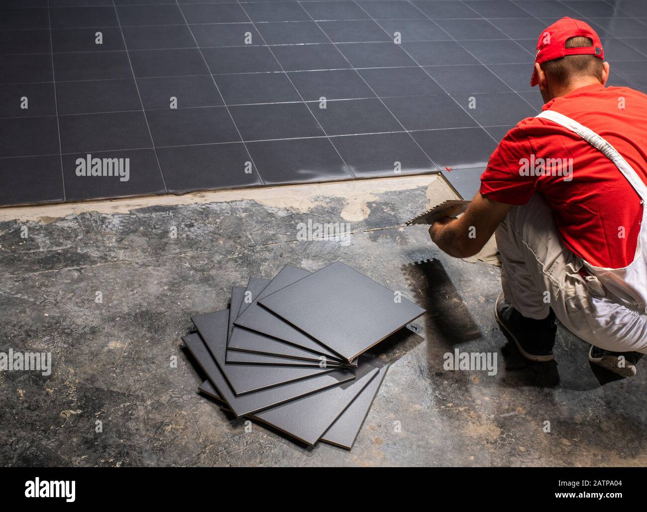 A construction worker putting on new floor tiles Stock Photo - Alamy