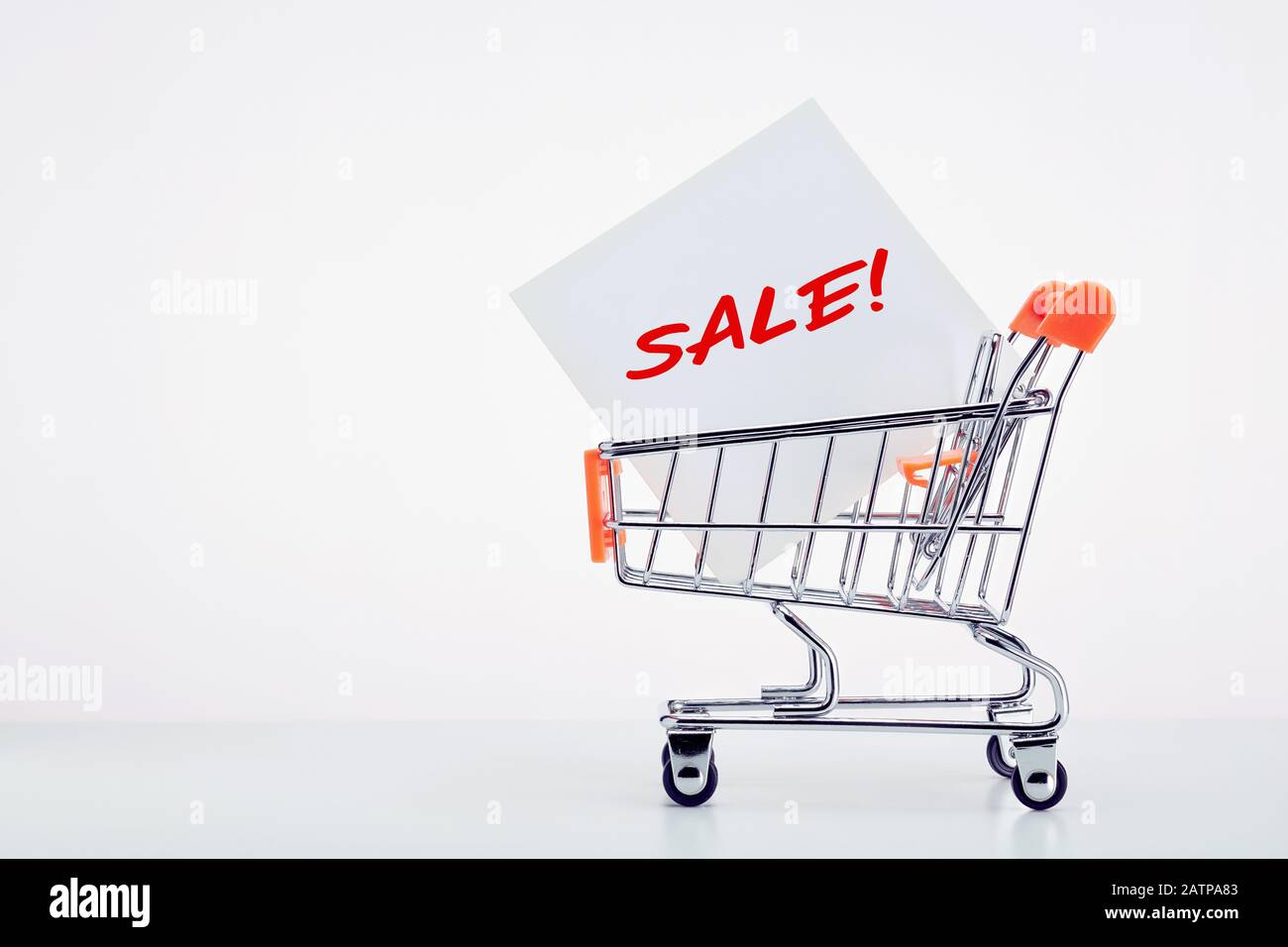 Shopping cart with a note paper writing sale on it on white background ...