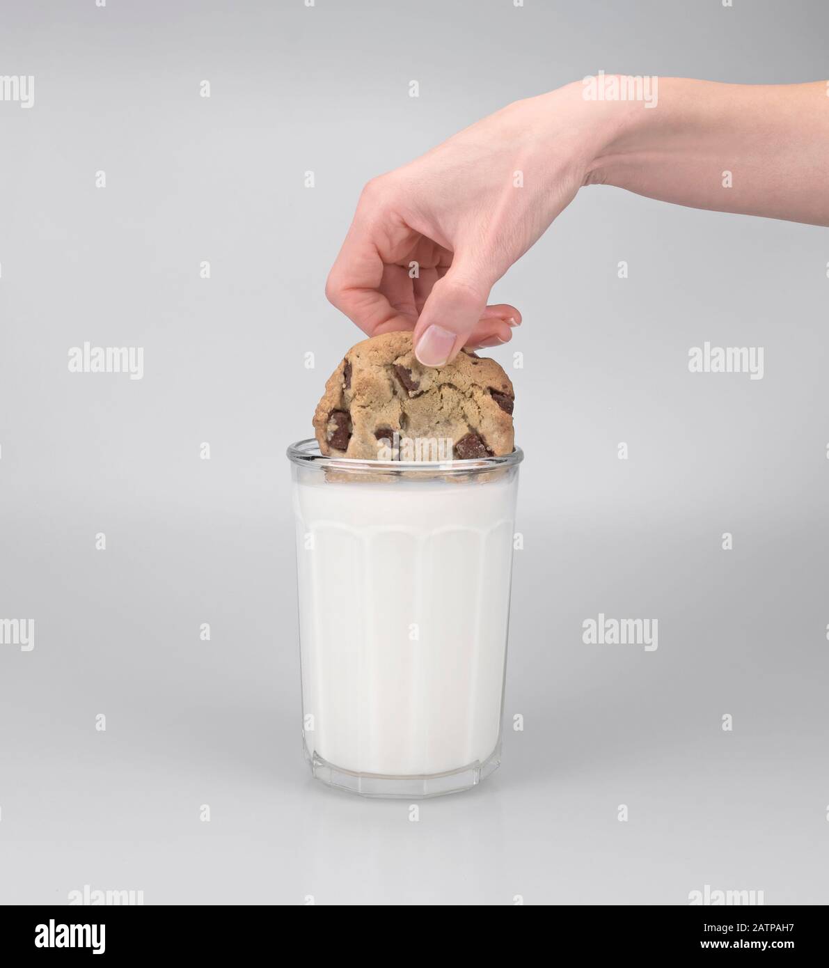 Dunking chocolate chip cookie in milk Stock Photo - Alamy