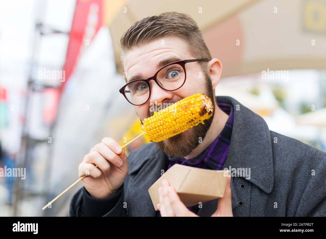 Man eating grilled corn. vegetarian food. healthy and tasty vegetables ...