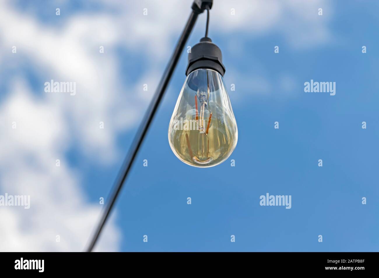 Outdoor lightbulb against cloudy blue sky Stock Photo - Alamy