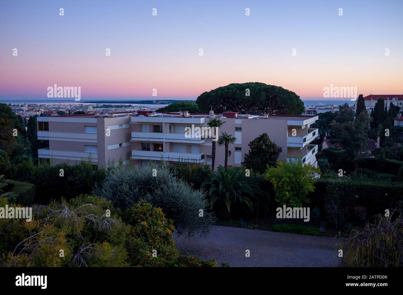 view of Cannes, France at sunset with buildings and the Mediterranean ...