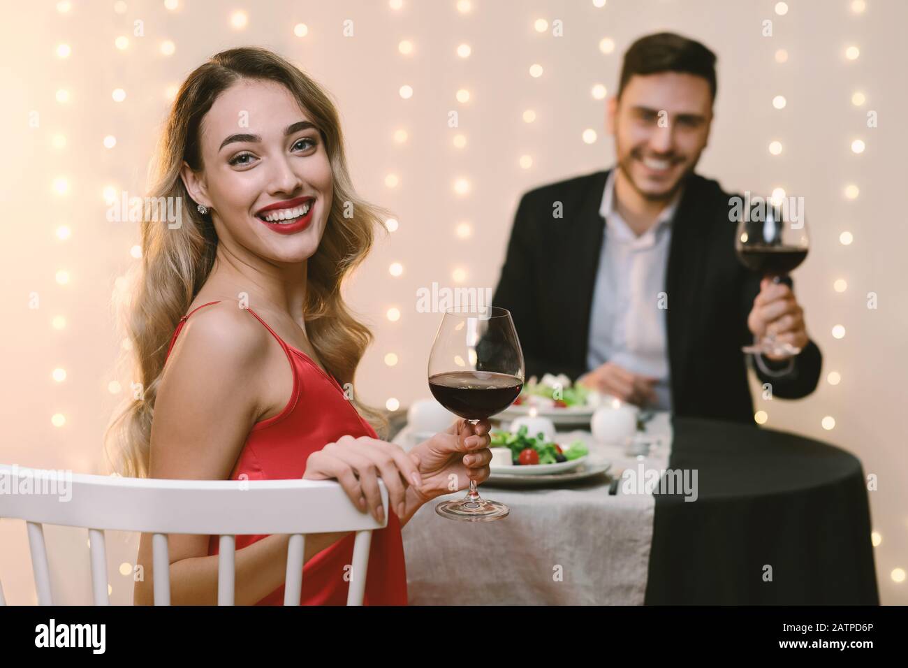 Millennial couple having romantic dinner together, posing to camera in ...