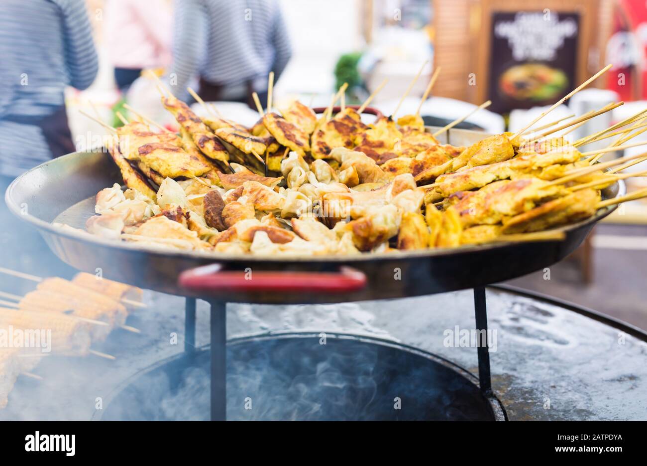 Street Food at outdoor market concept. Grilled chickens inserted on ...