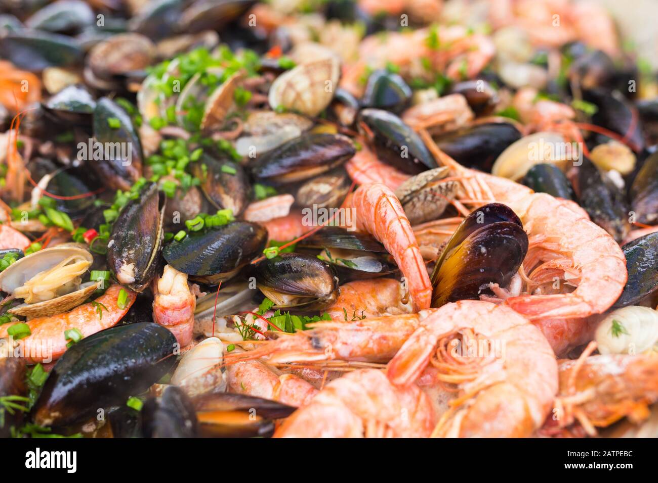 Street food concept - Gourmet seafood paella with pink marine prawns ...