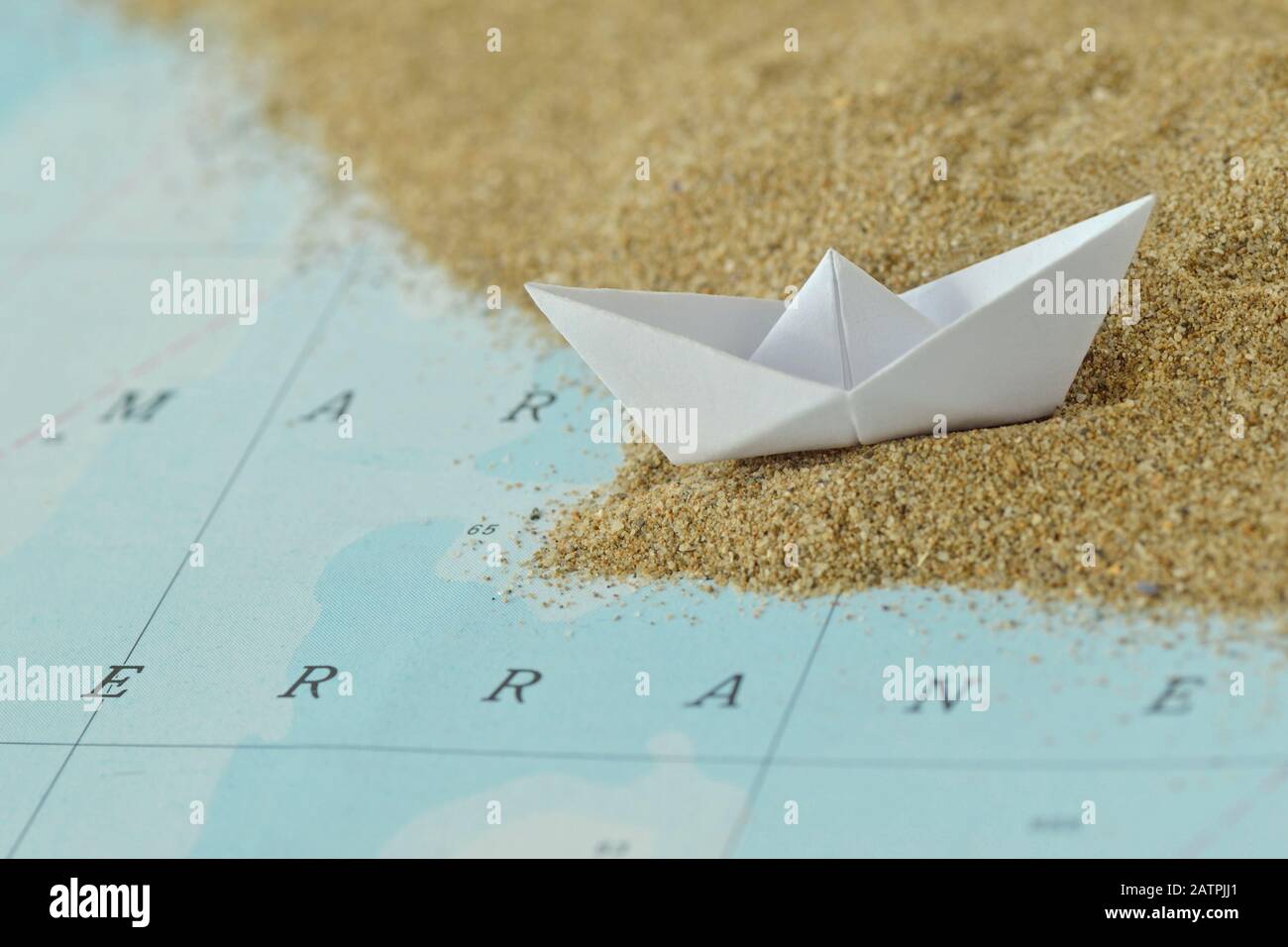 Paper boat on a map with sand - Immigration concept Stock Photo - Alamy