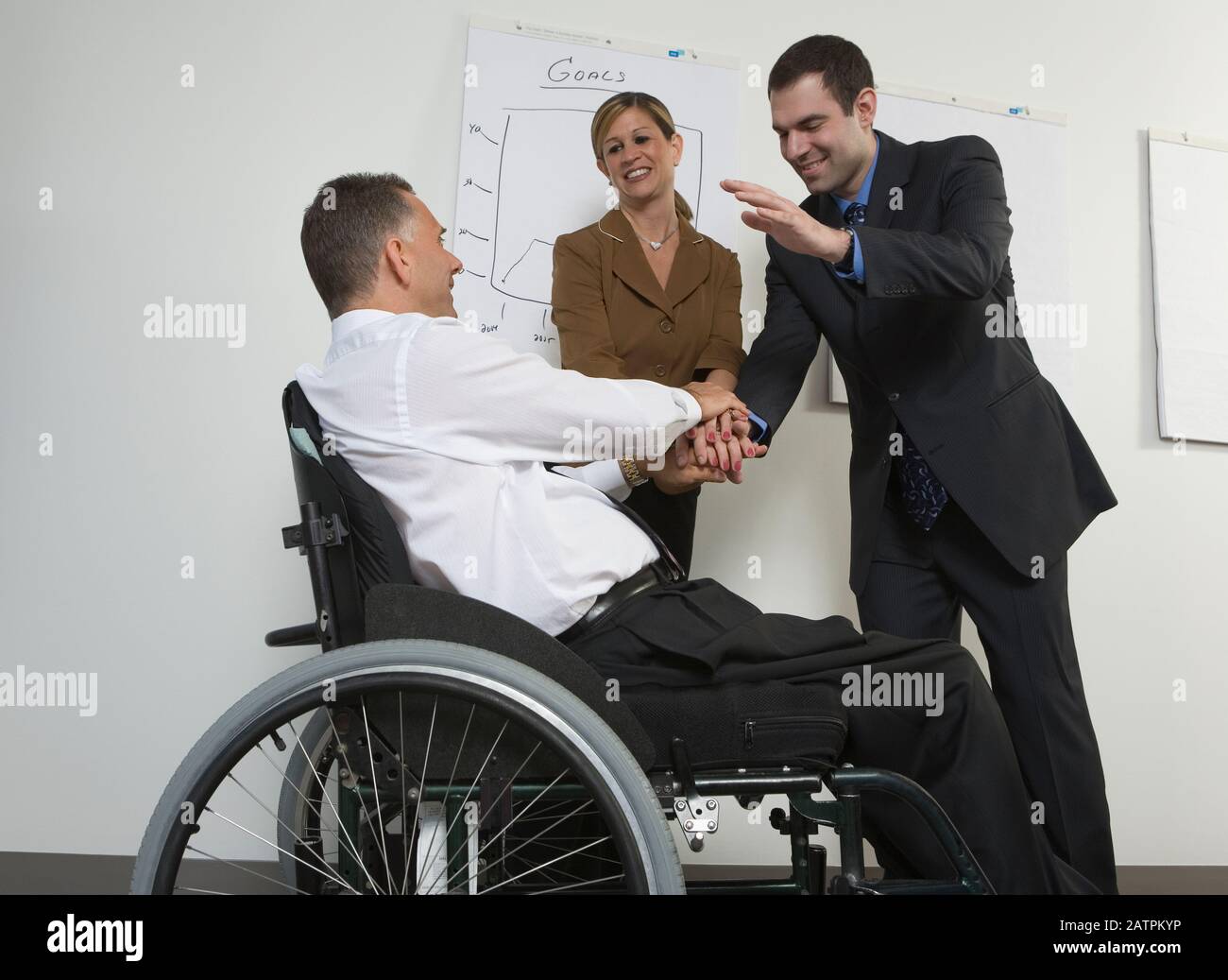 Three business executives doing hands stack Stock Photo - Alamy