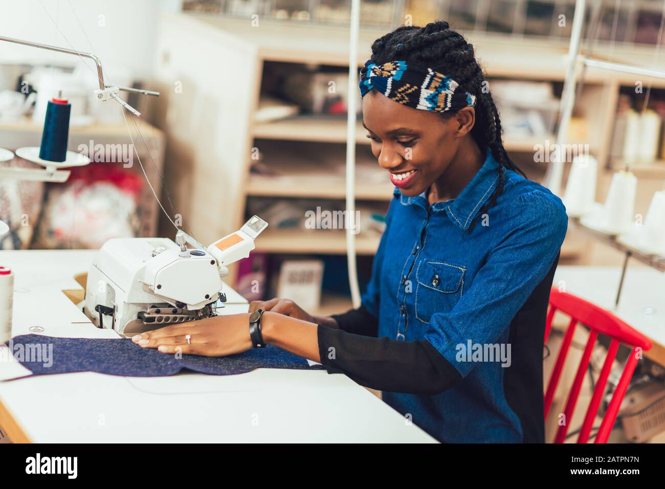 Young african textile worker sewing on production line. Dressmaker ...