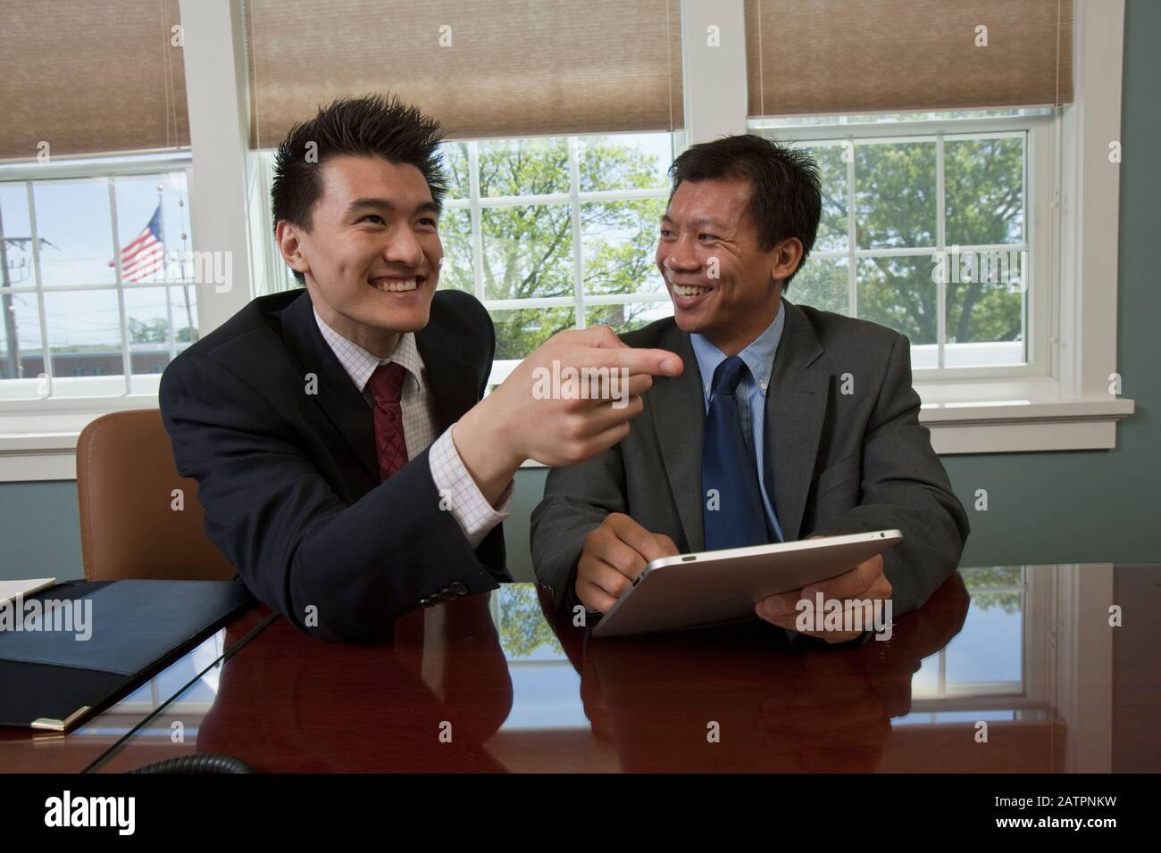 Businessmen sitting in their workplace laughing together Stock Photo ...