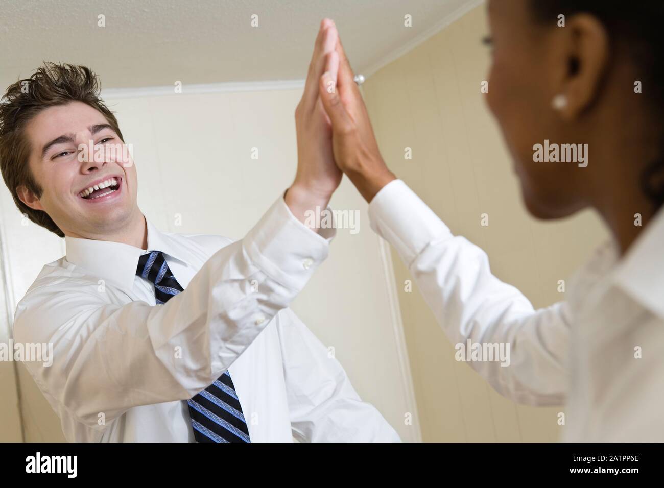 View of a young man and woman doing high five Stock Photo - Alamy
