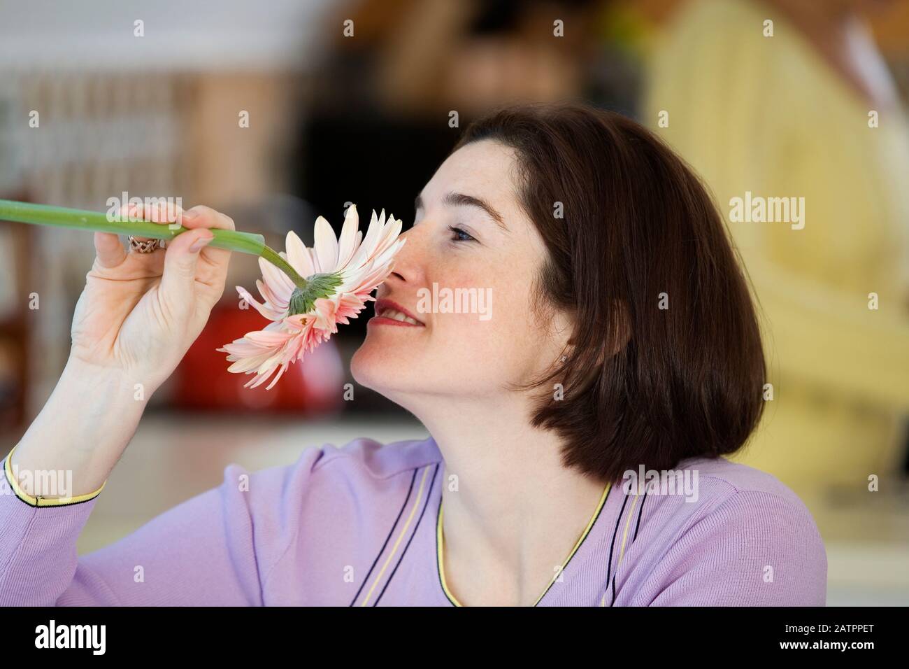 A woman smelling a daisy Stock Photo - Alamy