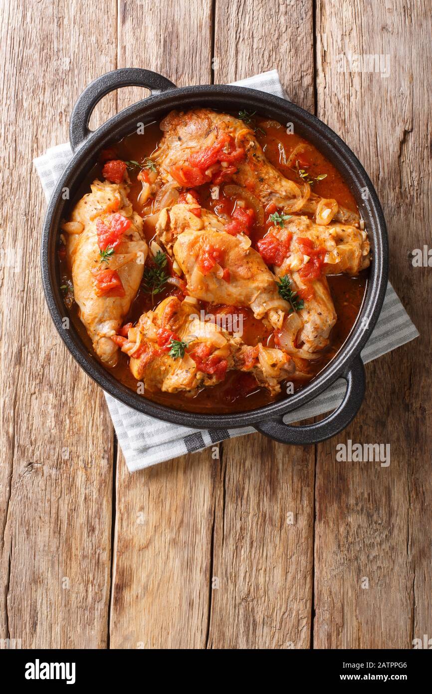 Braised rabbit in tomato sauce with white wine and herbs close-up in a ...
