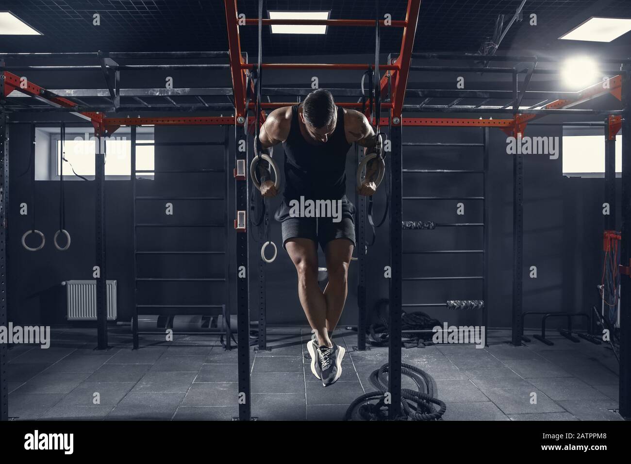 Flying hard. Young muscular caucasian athlete practicing pull-ups in ...