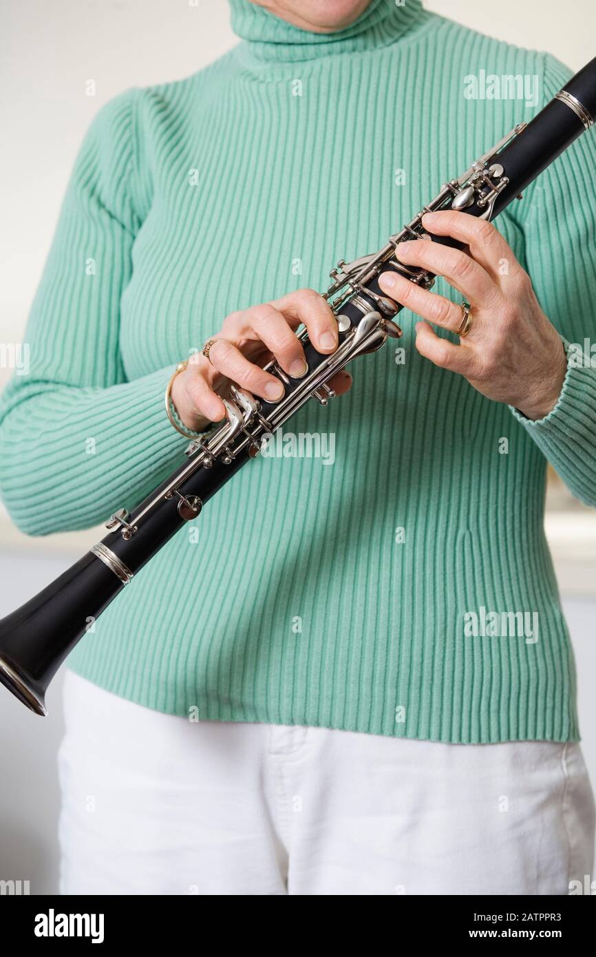 Midsection of a mature woman standing with a clarinet Stock Photo - Alamy