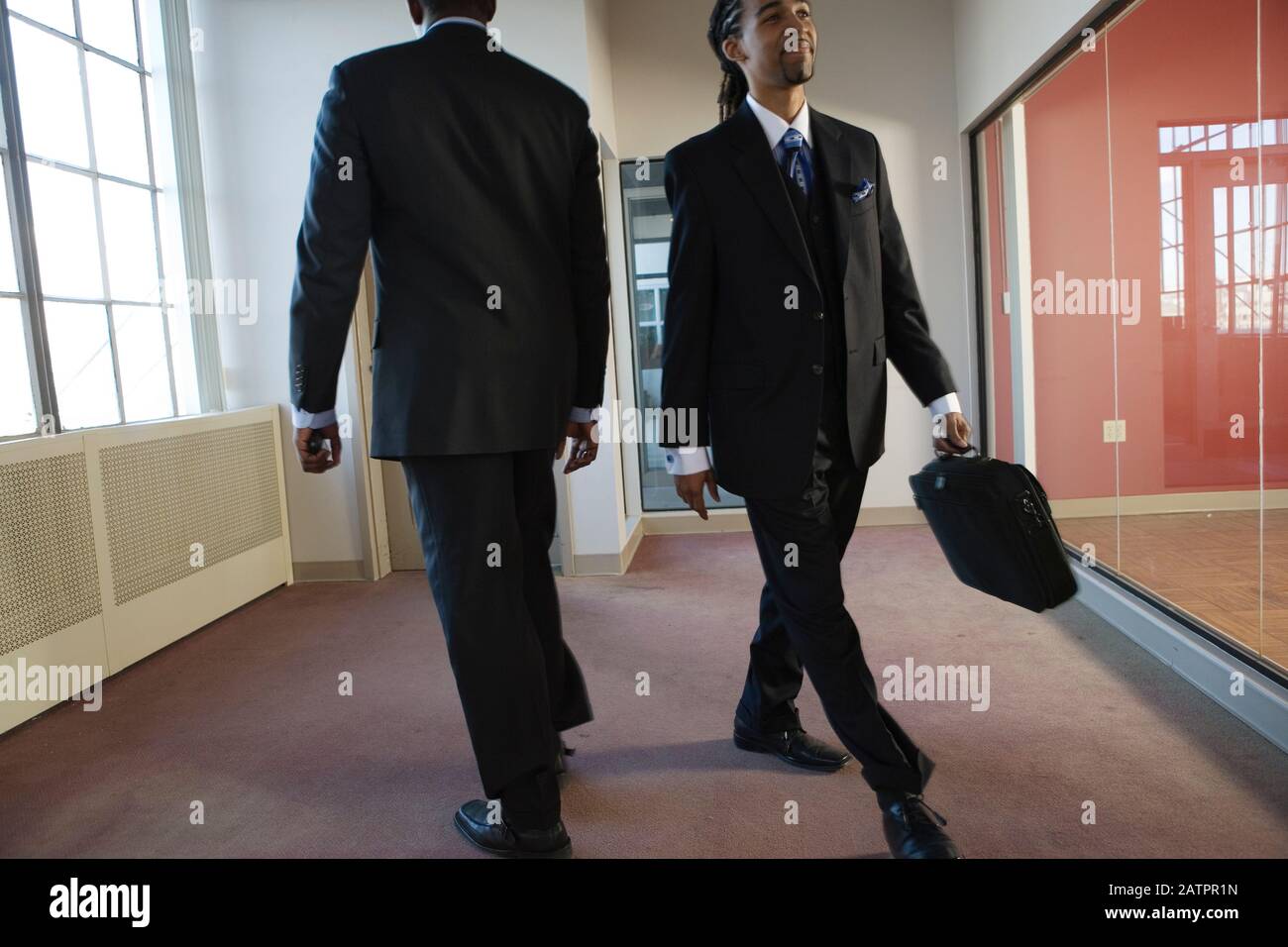 Businessmen walking in an office Stock Photo - Alamy