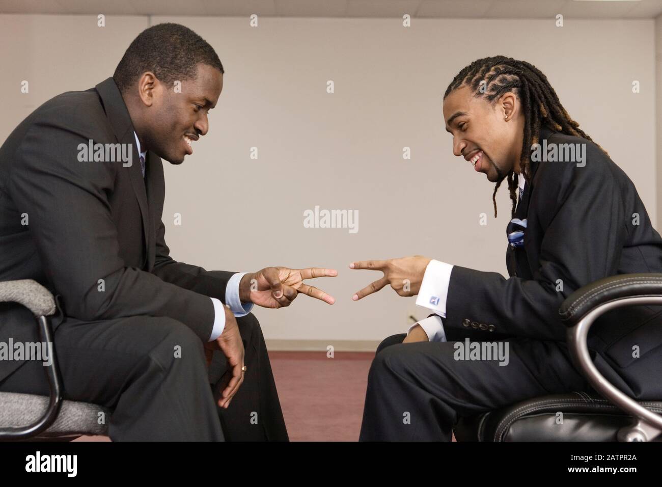 Businessmen playin Rock Paper Scissors Stock Photo - Alamy
