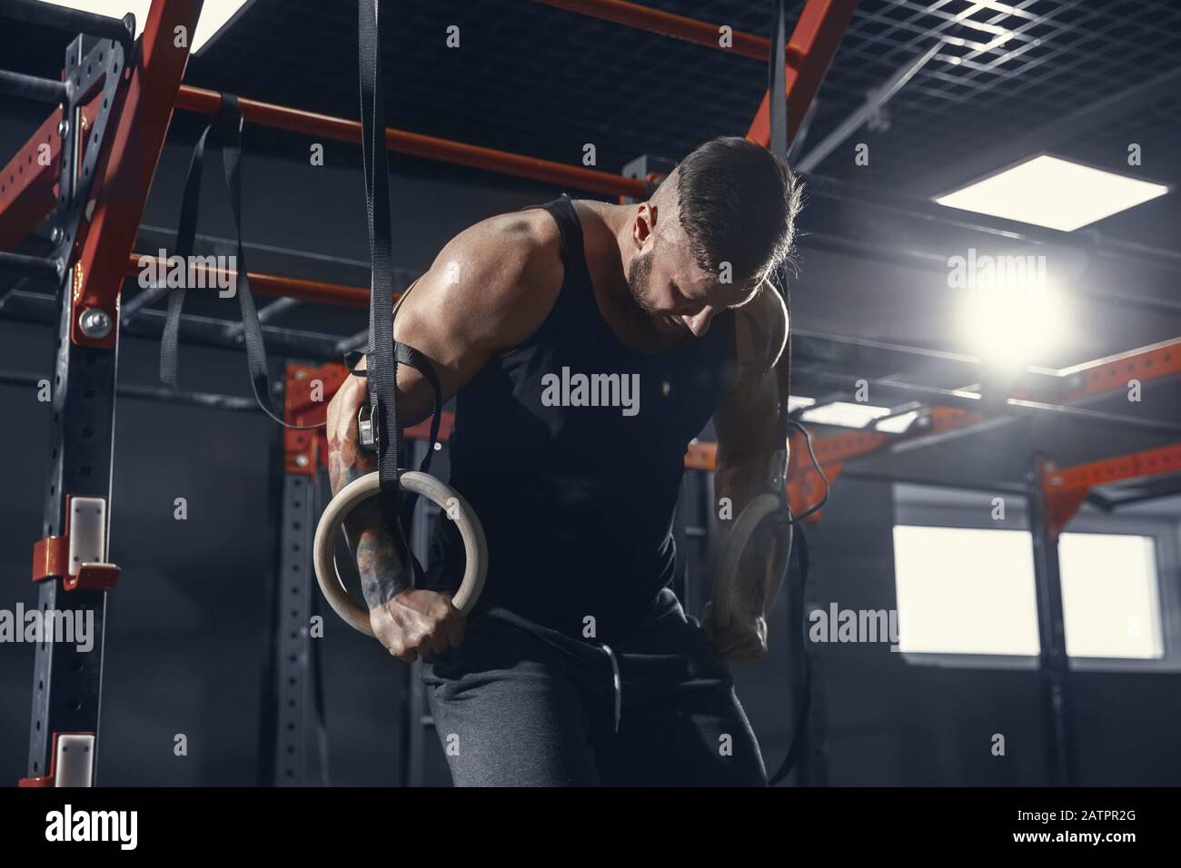 Flying hard. Young muscular caucasian athlete practicing pull-ups in ...
